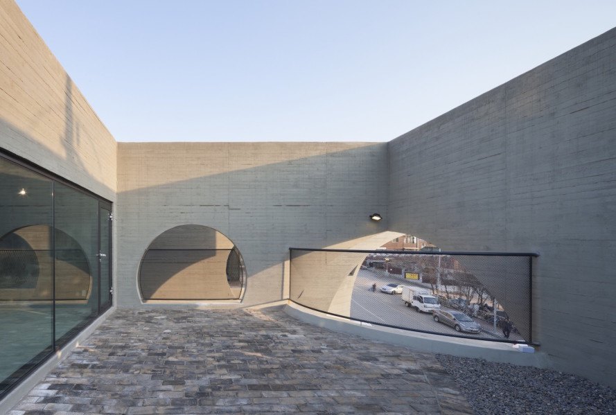Crescent-shaped cutouts give Moon Hoon’s Two Moon building its playful edge